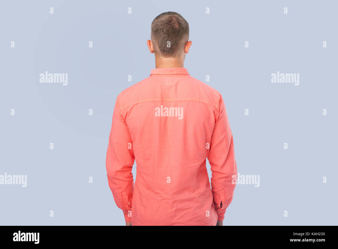 man in red shirt turned a back on gray background Stock Photo - Alamy