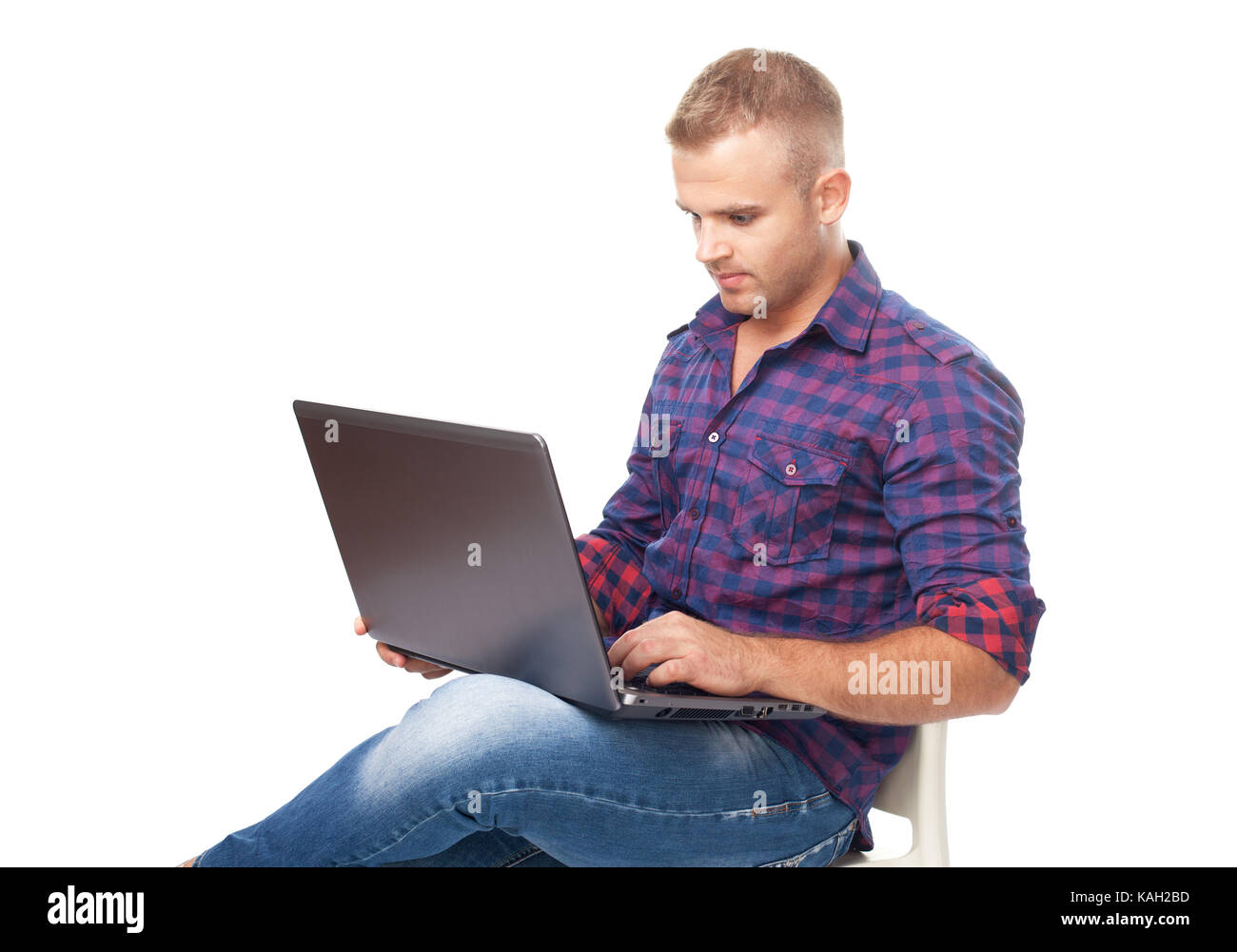 Young man sitting in chair and working on laptop computer isolated on ...