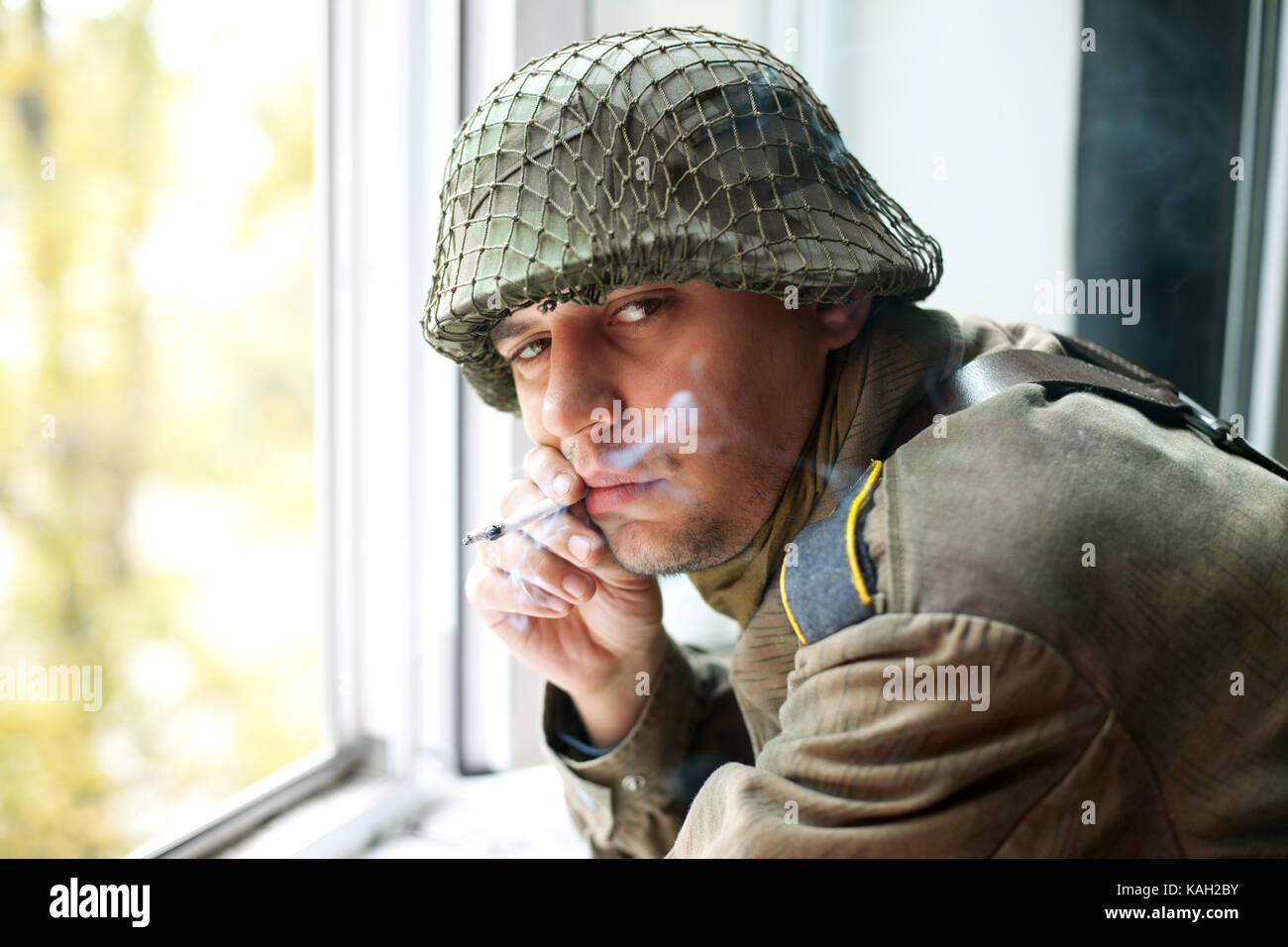 Soldier smoking near a window Stock Photo - Alamy