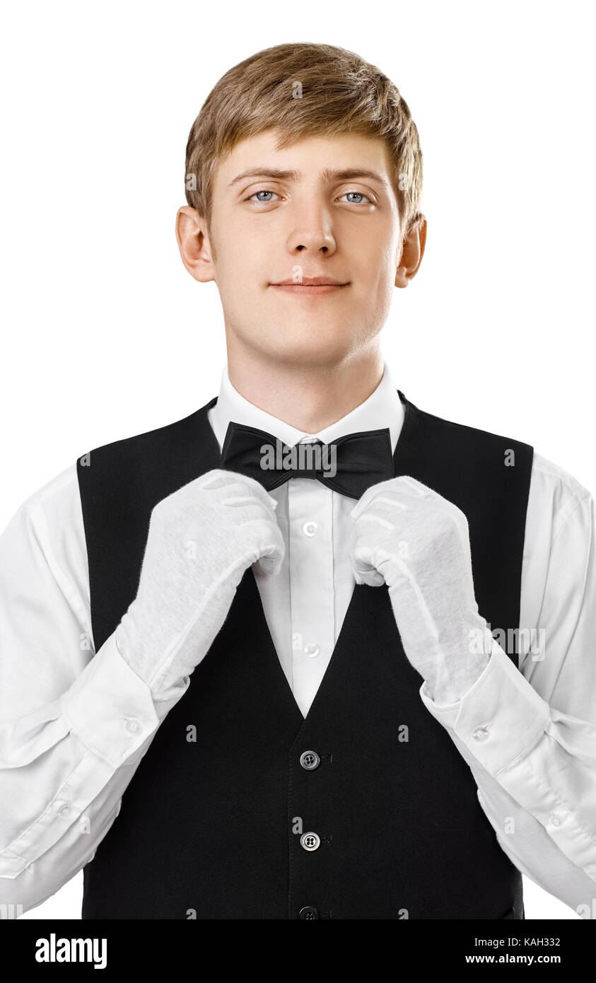 Portrait of young handsome waiter fixing his bow tie on a suit isolated ...