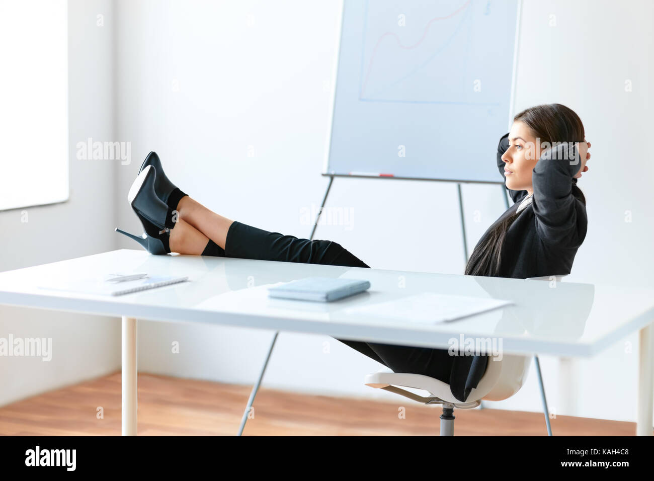Businesswoman sitting desk legs up hi-res stock photography and images ...