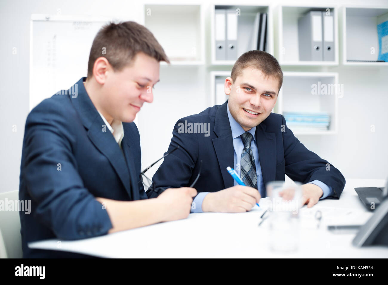 Two happy young business men working together in the office Stock Photo ...