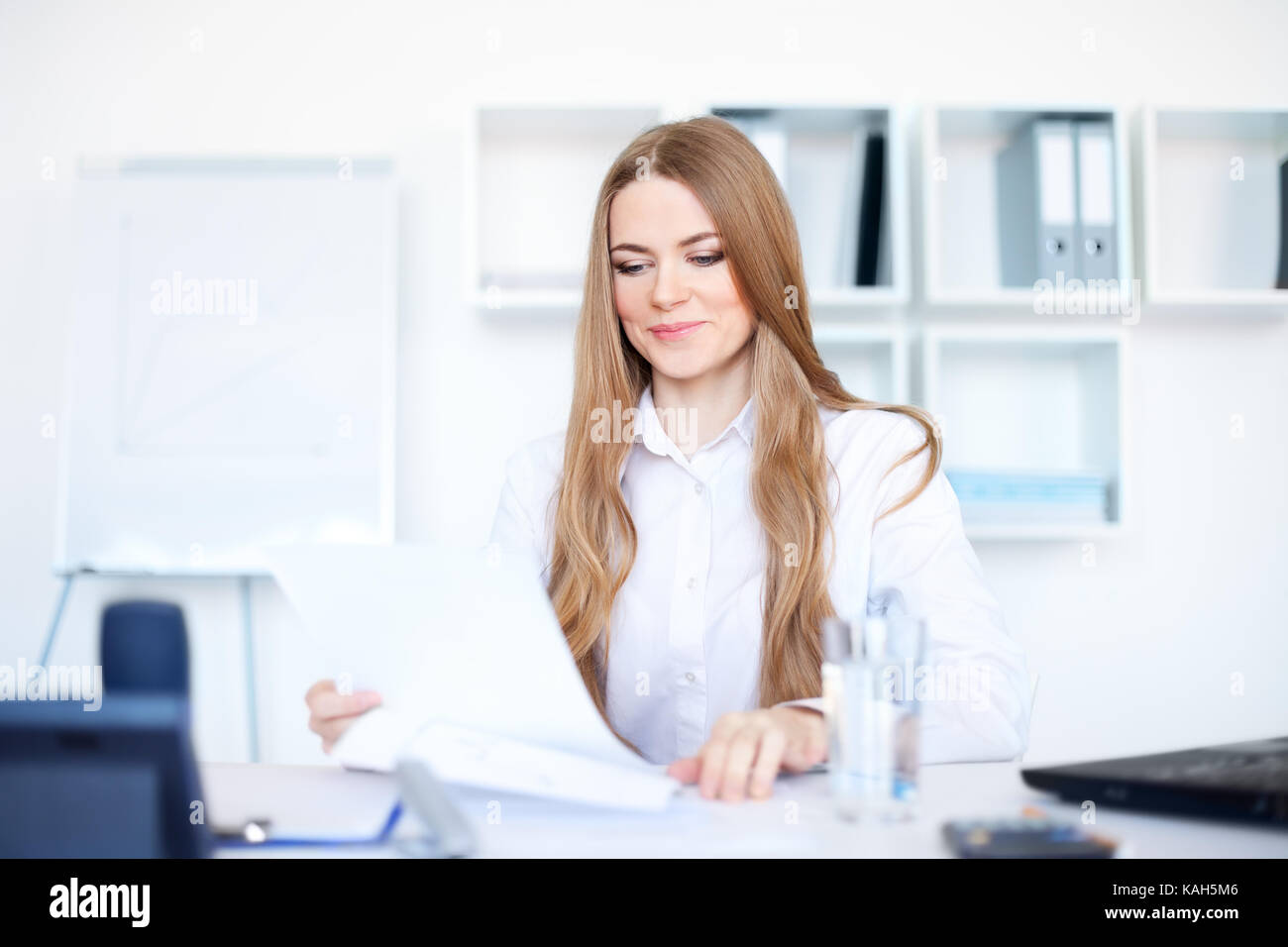 Portrait of a beautiful young smiling business woman doing some ...