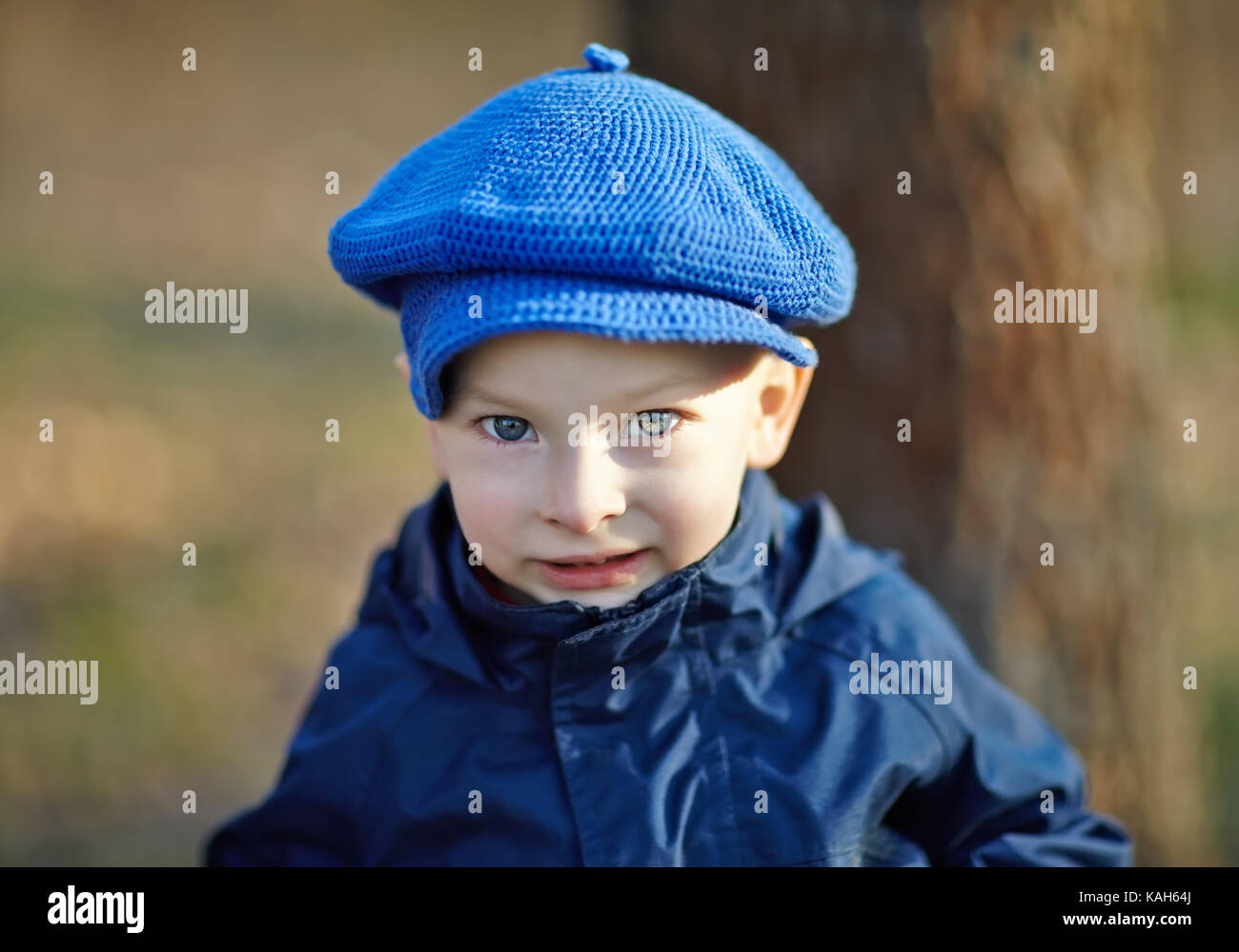 Close-up portrait of cute little boy wearing a blue hat in the autumn ...