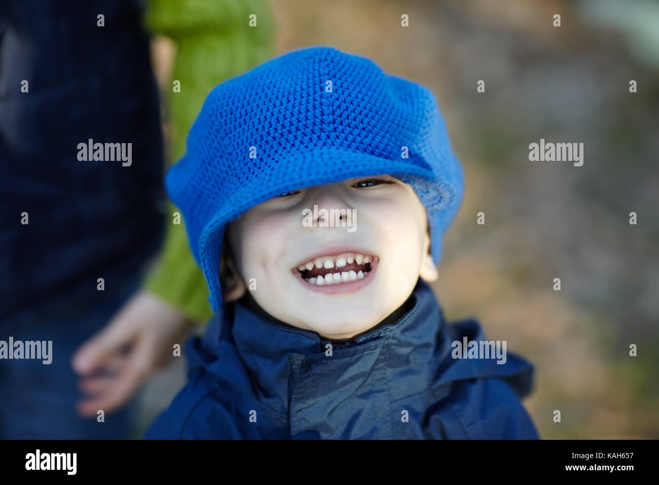 Close-up portrait of funny little boy wearing a big blue hat in the ...