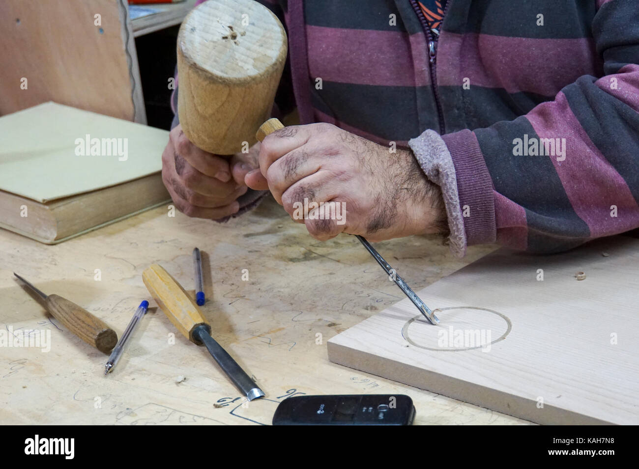 A man engraving a block of wood with a mallet and chisel Stock Photo ...