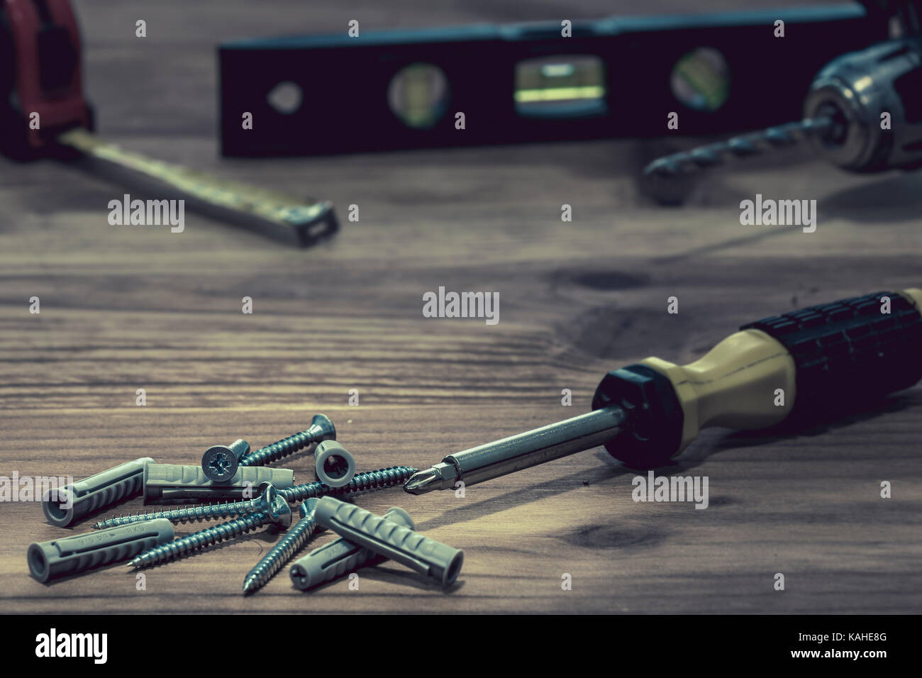 Screwdriver and pile of screws on wooden table with vintage effect ...