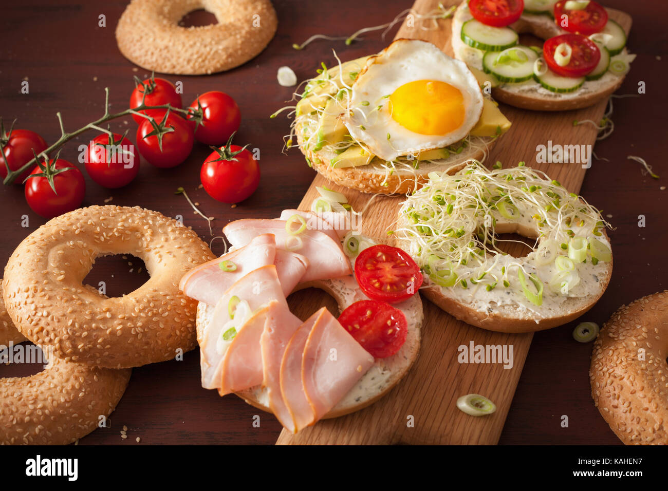 variety of sandwiches on bagels: egg, avocado, ham, tomato, soft cheese ...