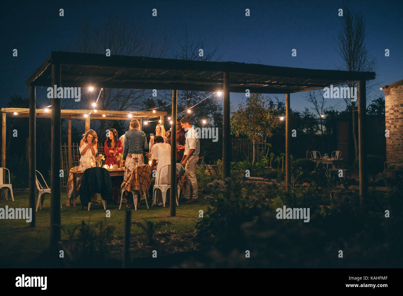 Group of people having a dinner party. Men and women standing around a ...