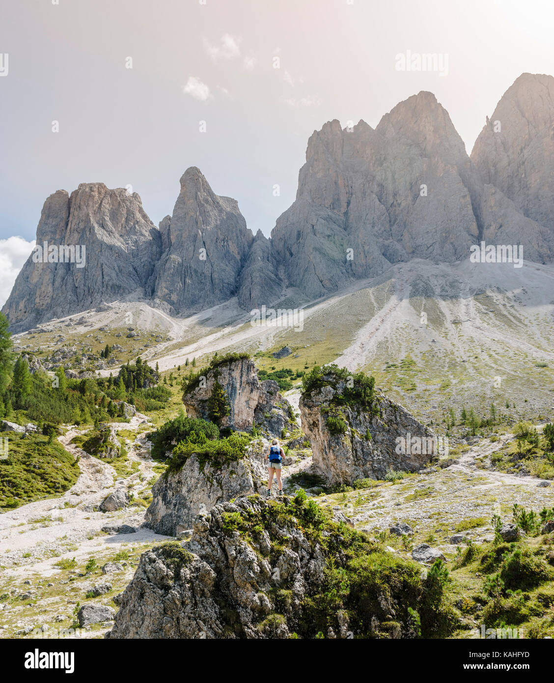 Hiker standing on rocks, scree field below the Geisler Peaks, behind ...
