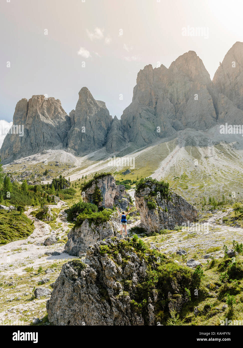 Hiker standing on rocks, scree field below the Geisler Peaks, behind ...