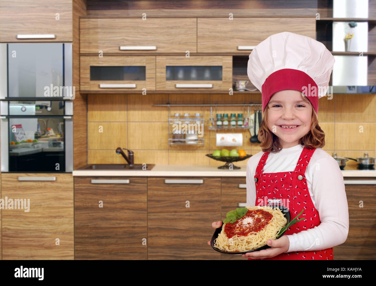happy little girl cook with delicious spaghetti in kitchen Stock Photo ...
