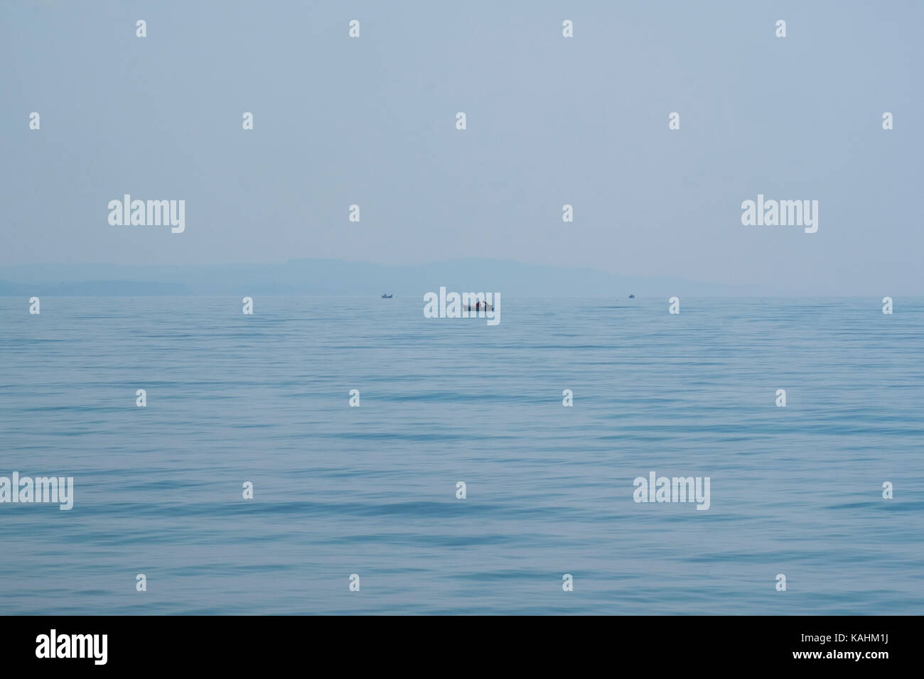 Two people fishing in a boat off the Jurassic Coast at Lyme Regis ...