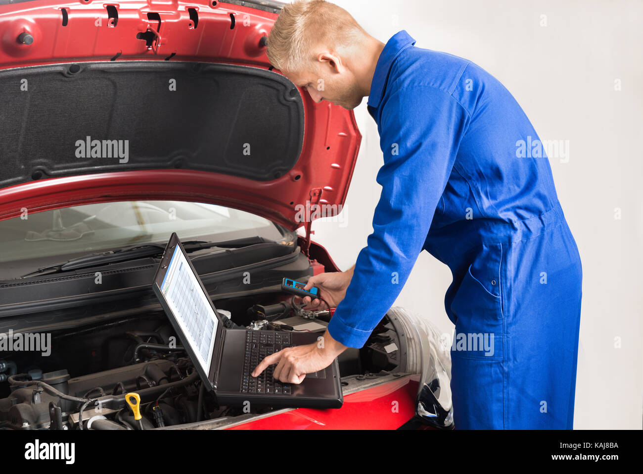 Mechanic Using Laptop While Repairing Car In Garage Stock Photo - Alamy