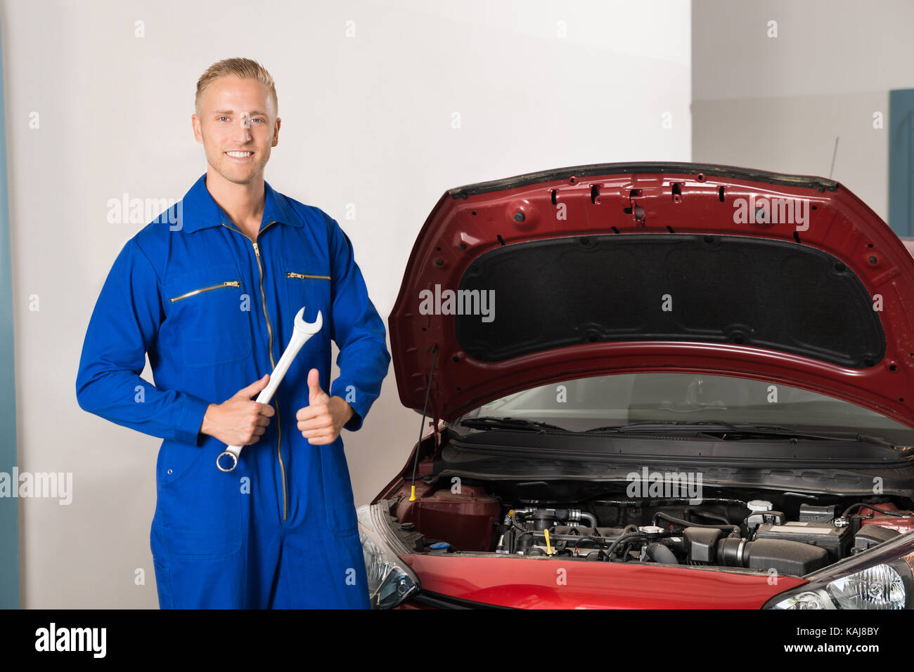 Car Mechanic Standing In Front Of Car With Tool In His Hand Stock Photo ...