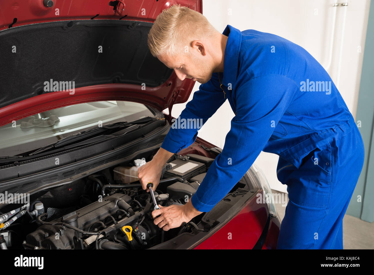 Mechanic Using Screwdriver For Repairing Car In Garage Stock Photo - Alamy