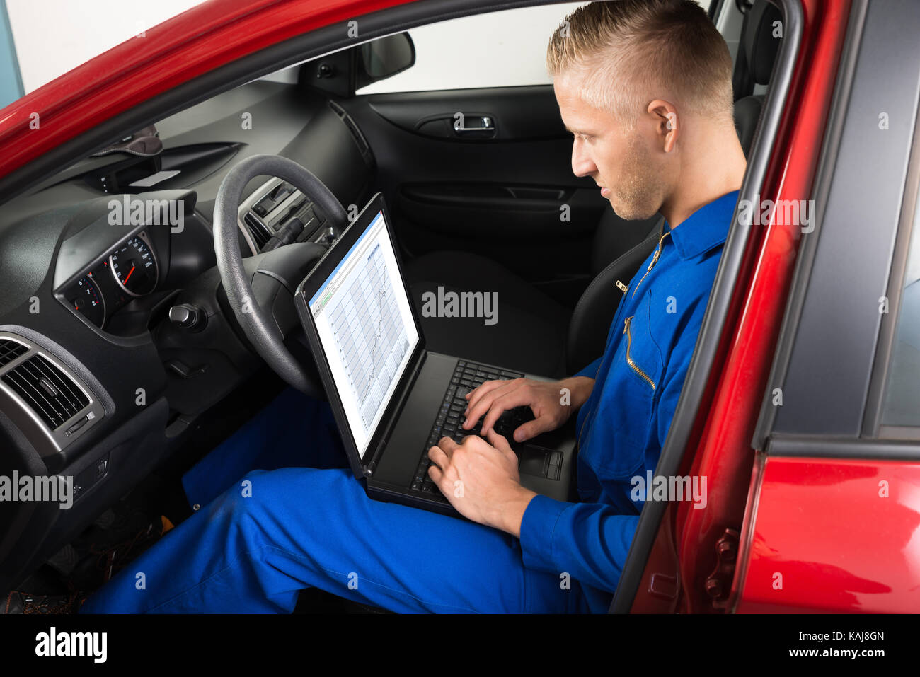 Young Mechanic Sitting In Car And Using Laptop Stock Photo - Alamy