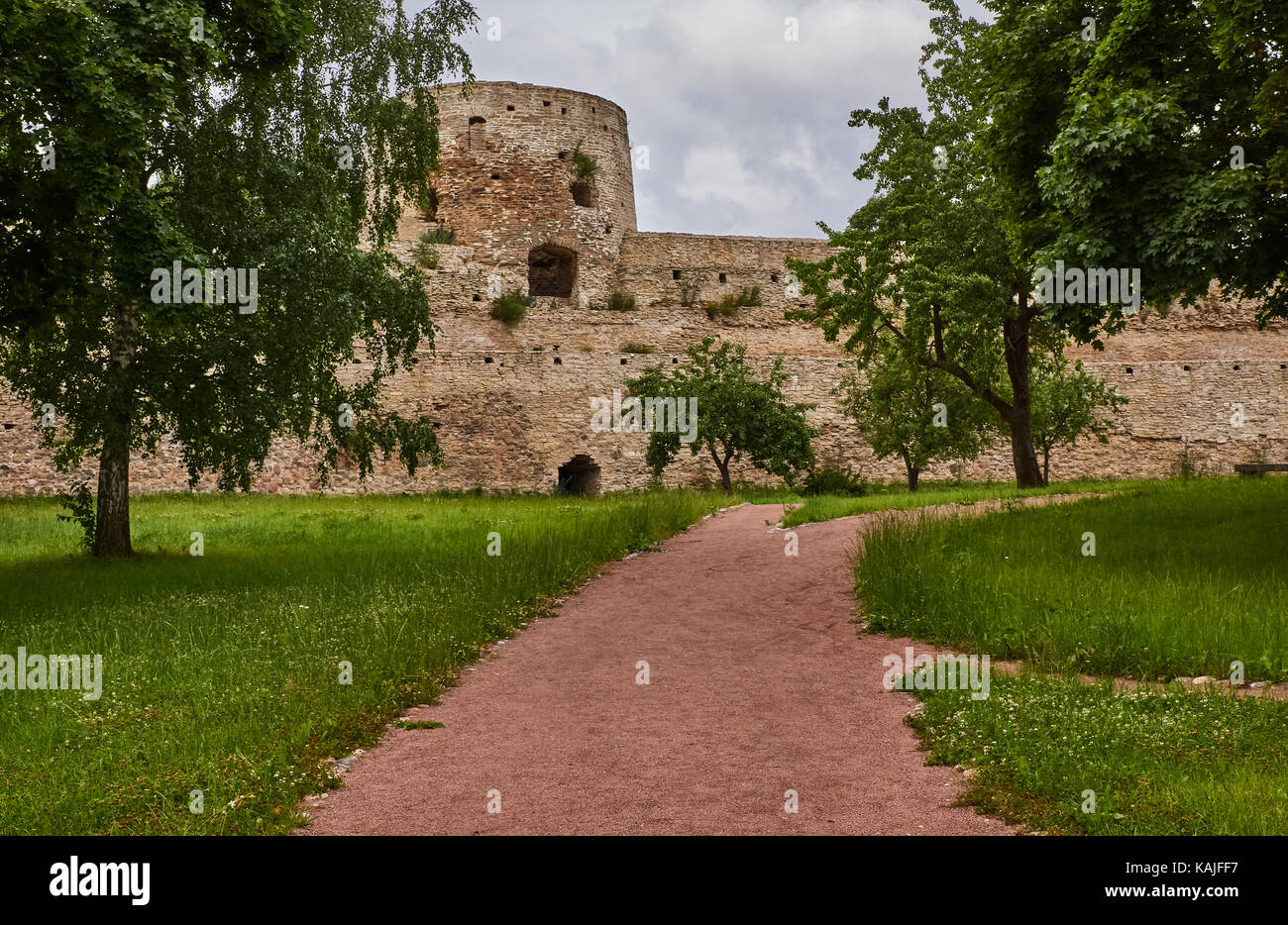 An ancient fortress wall with watchtowers. Before the wall grows a ...