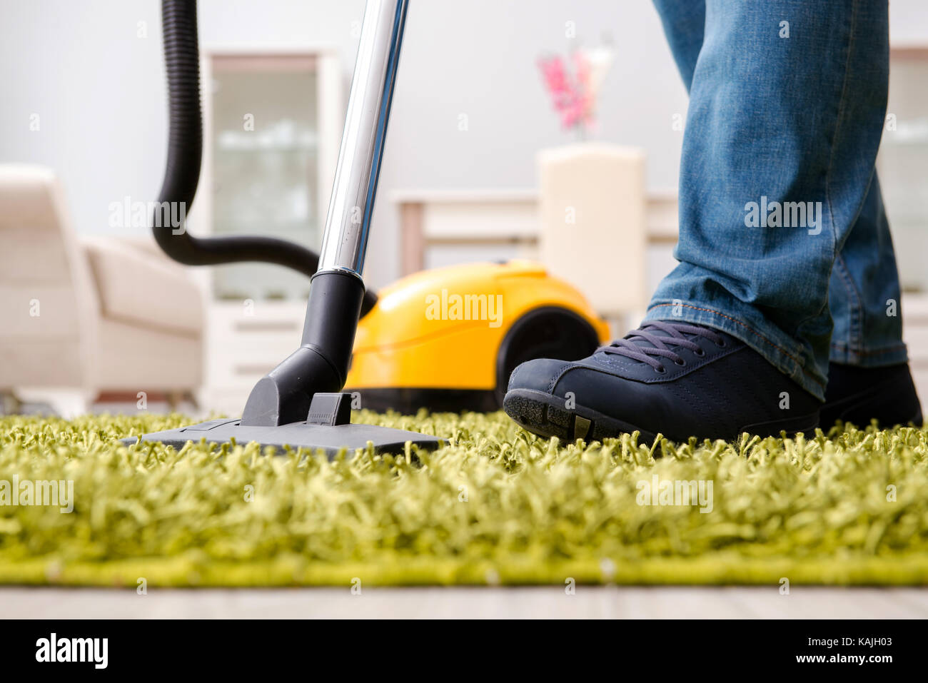 Man cleaning the floor carpet with a vacuum cleaner close up Stock ...