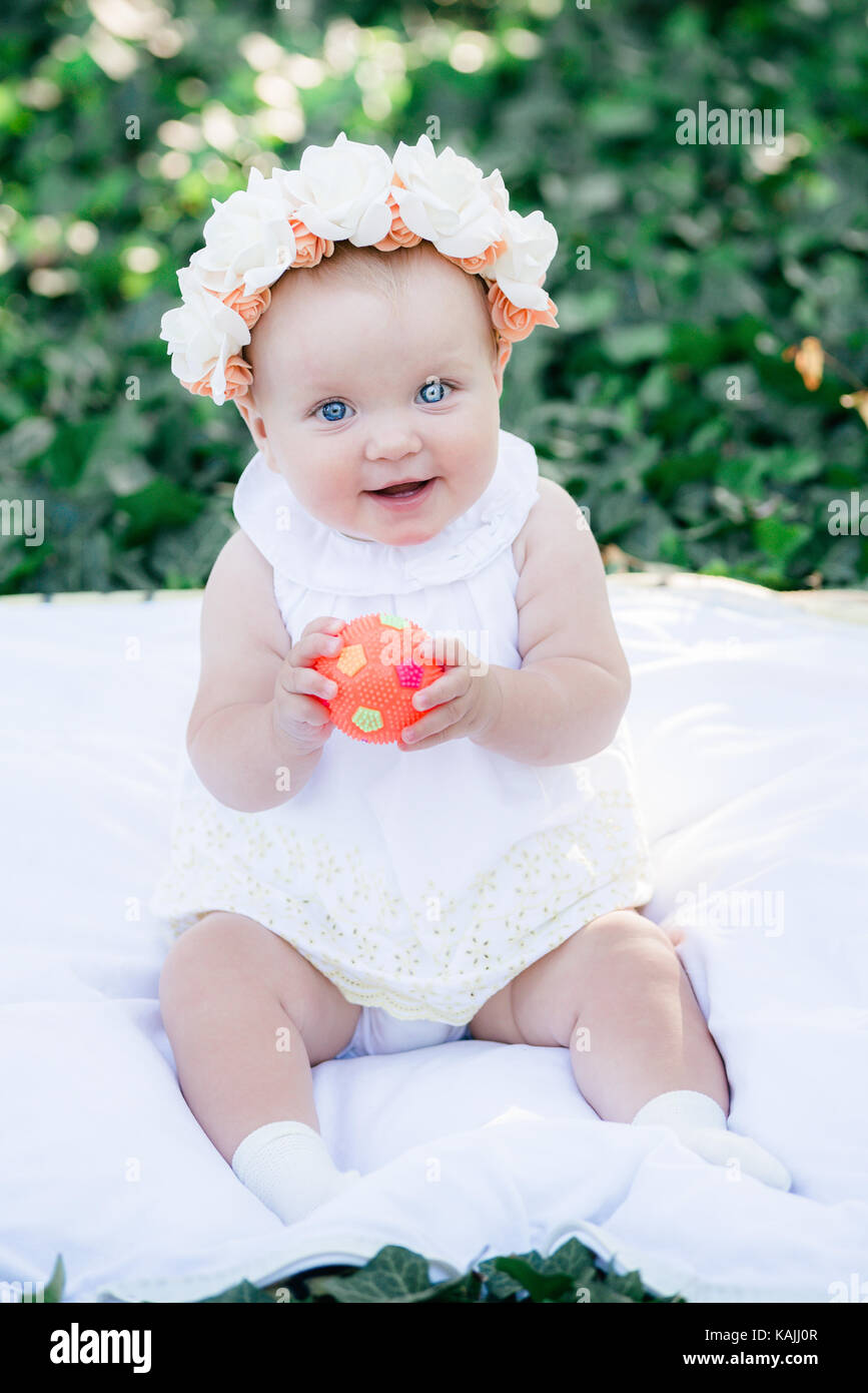 baby girl 8 months old portrait looking up to camera outdoors in ...