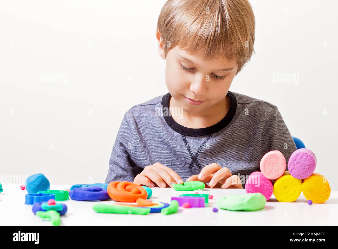 Boy playing and creating from modeling clay or plasticine Stock Photo ...