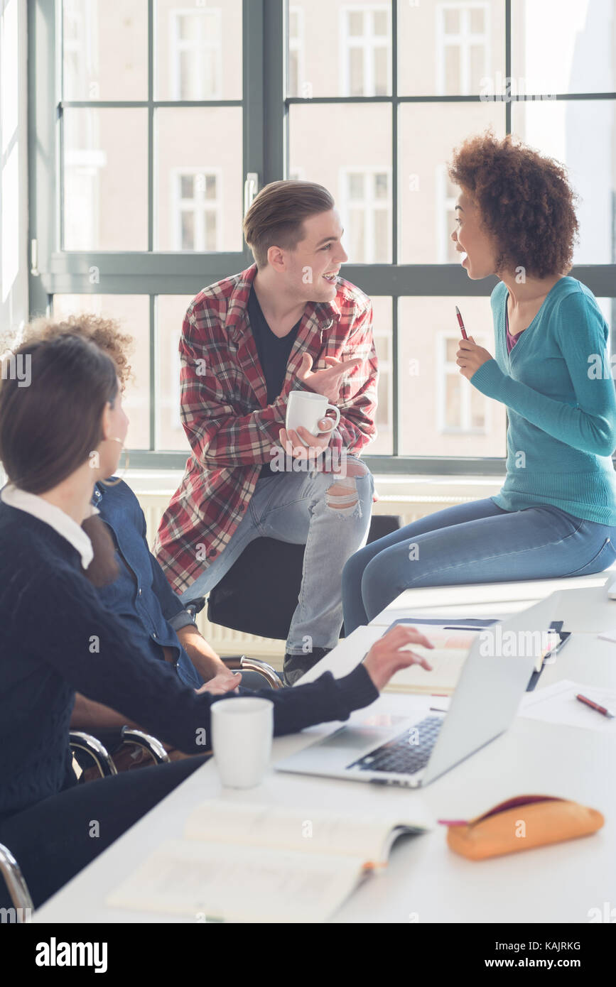 Cheerful students having a funny loud conversation during break in the ...