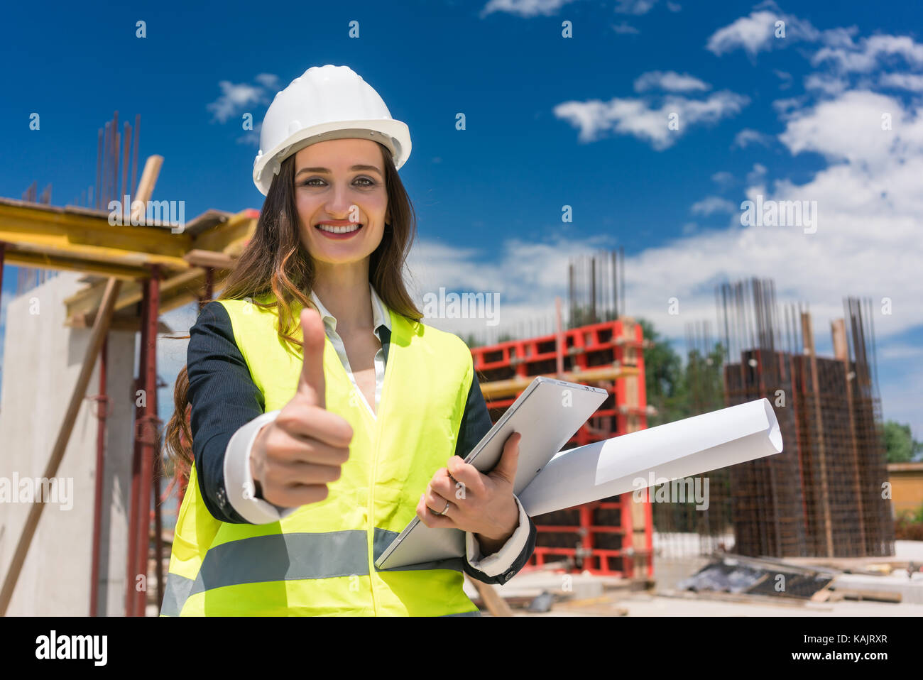Portrait of a happy female construction foreman or architect showing ...