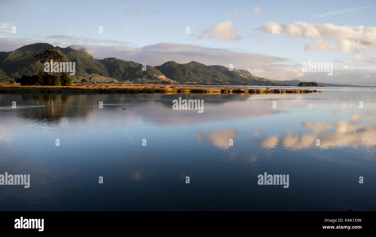 Beautiful mirror like reflection of the hills in the Aorere River Inlet ...
