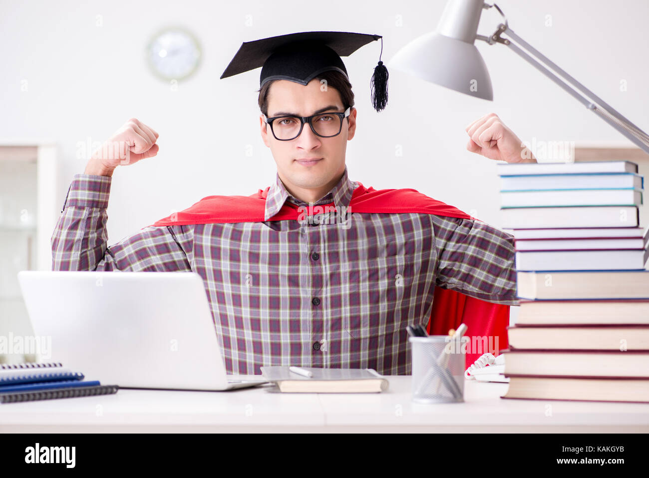 Super hero student wearing a mortarboard studying for exams Stock Photo ...