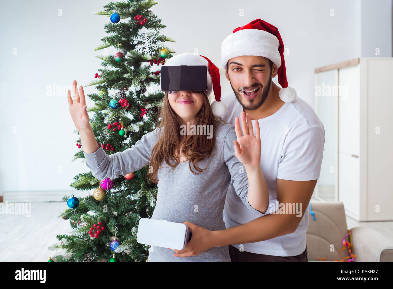 Young family expecting child baby wearing virtual reality VR glasses ...