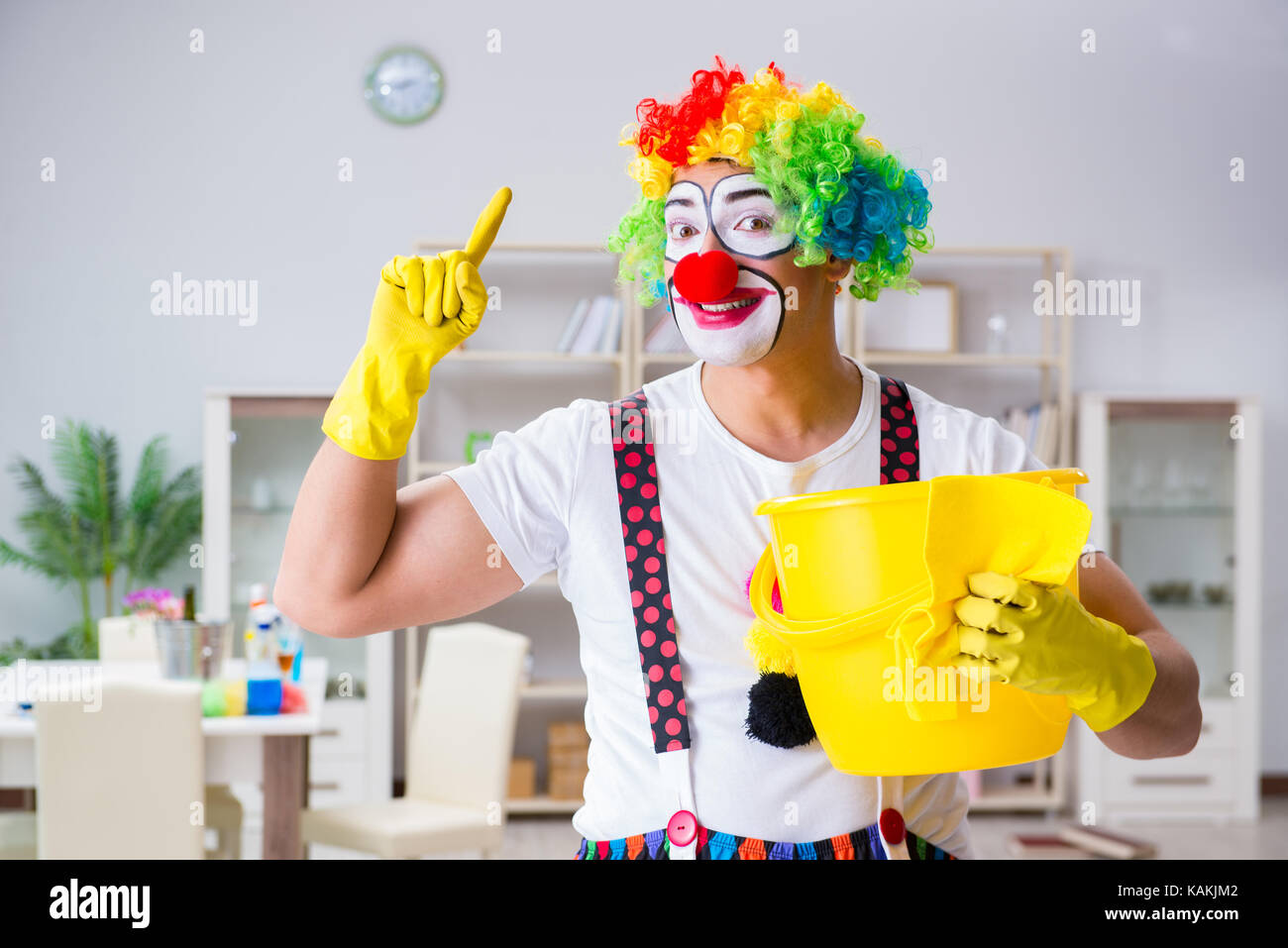 Funny clown doing cleaning at home Stock Photo - Alamy
