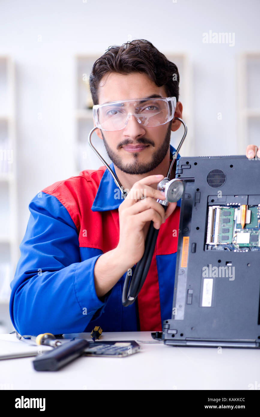 Repairman working in technical support fixing computer laptop ...