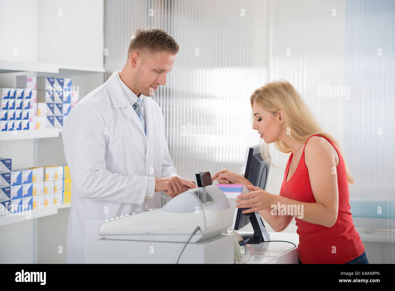 Young woman consulting pharmacist at counter in store Stock Photo - Alamy