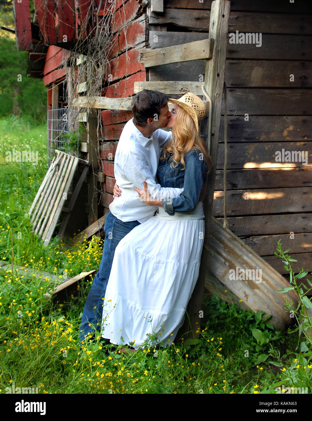 Couple enjoy a romantic kiss against a rustic and secluded setting. A ...