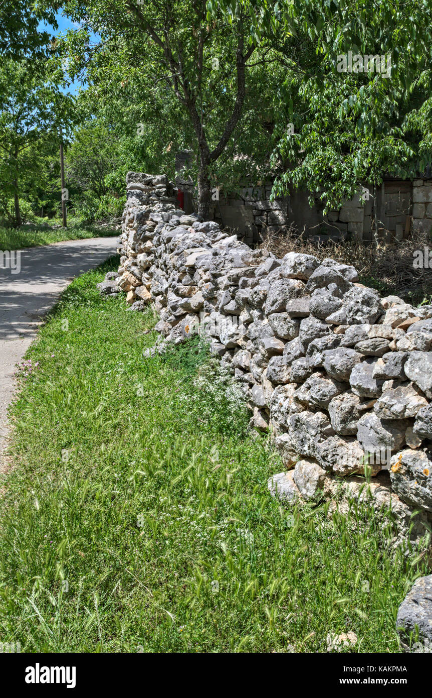 Stone fence beside road made of rocks Stock Photo - Alamy