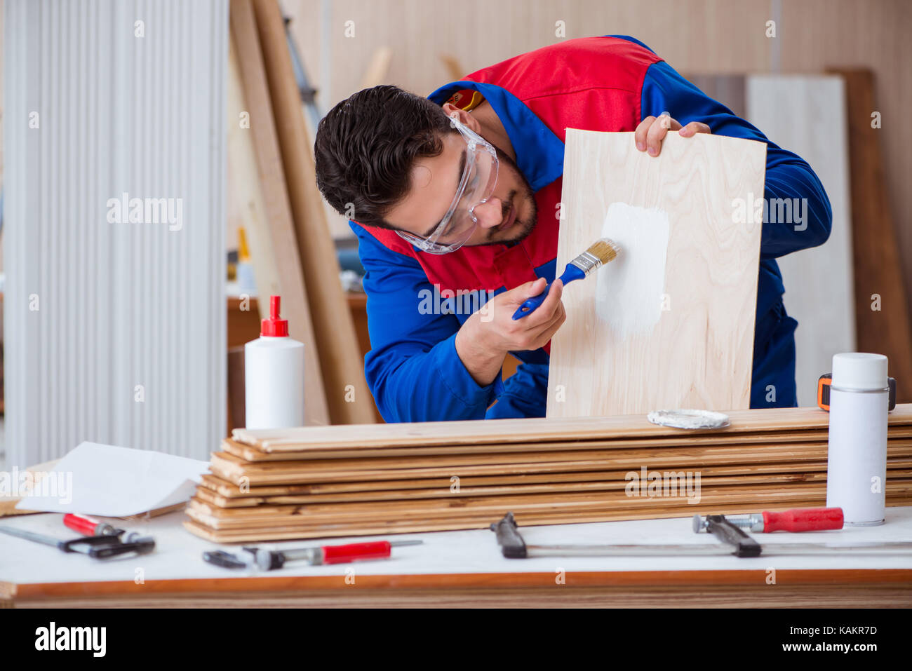 Yooung repairman carpenter working with paint painting Stock Photo - Alamy