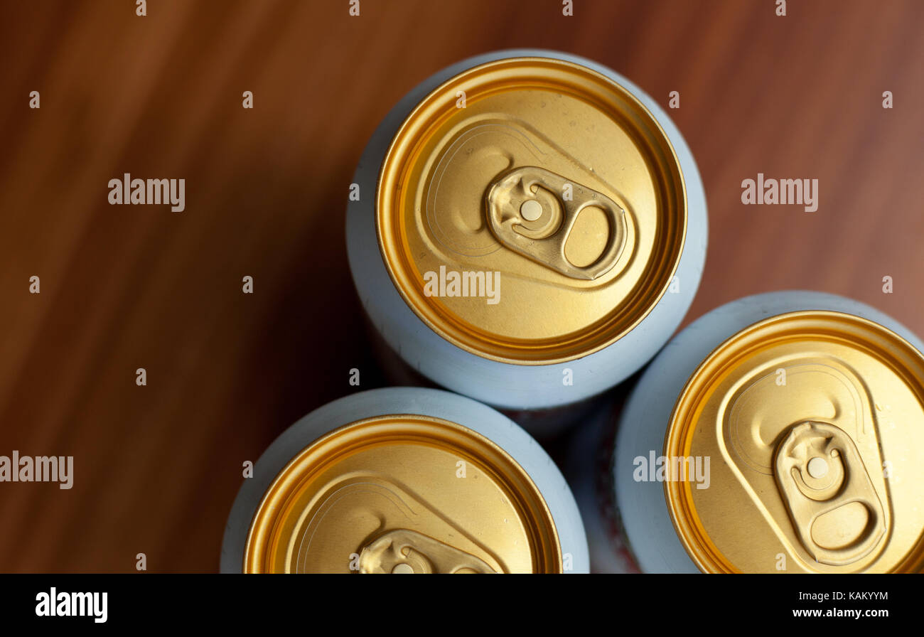 closeup photo of three beer cans on a wooden table Stock Photo - Alamy