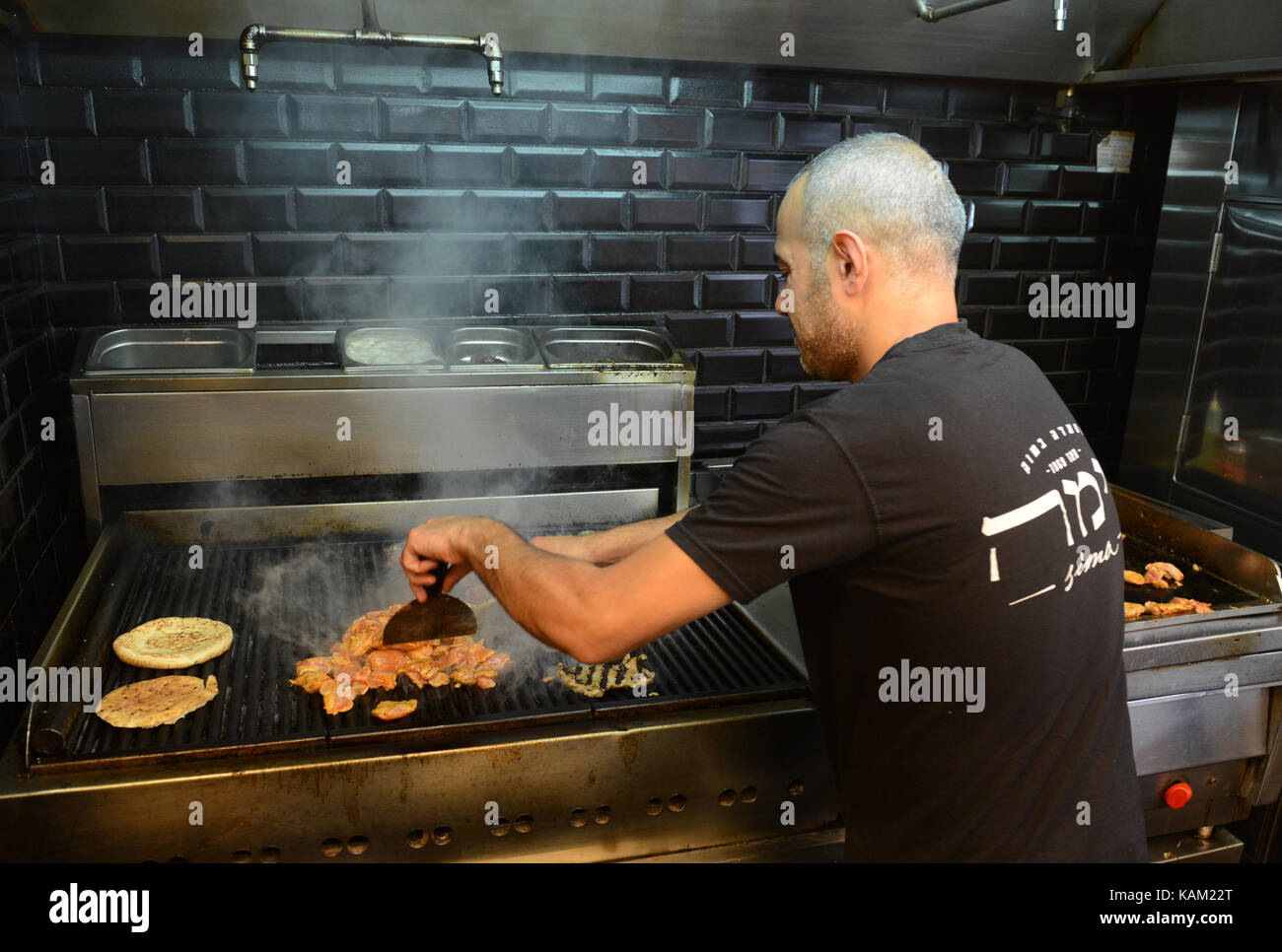 Grilling the meat at the popular Sima restaurant in Jerusalem's Mahane ...