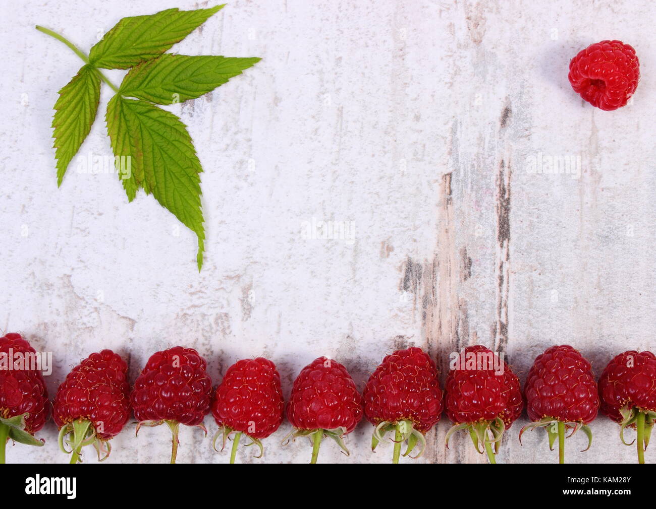 Fresh ripe raspberries with green leaf and copy space for text on old ...