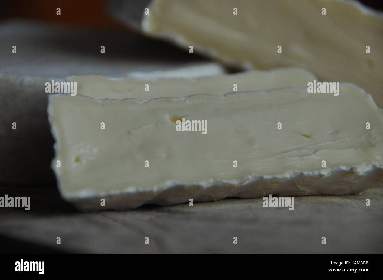 Cheese sliced on the board. Soft and fluffy Stock Photo - Alamy