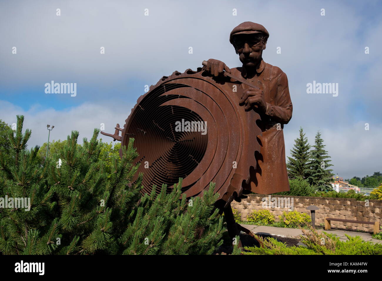 Steel sculpture of a traditional sawyer sharpening his giant saw blade ...