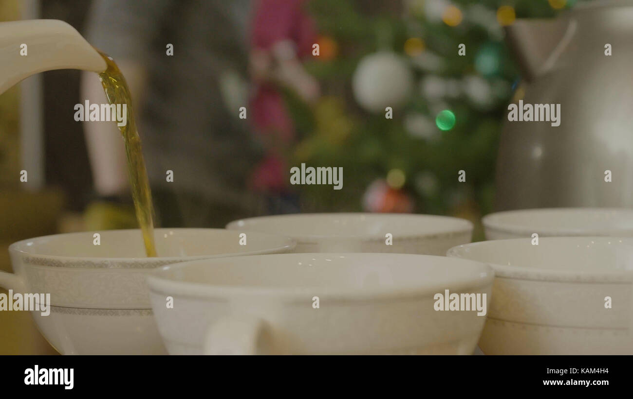 Tea being poured into tea cup. Kettle pours tea into cups Stock Photo ...