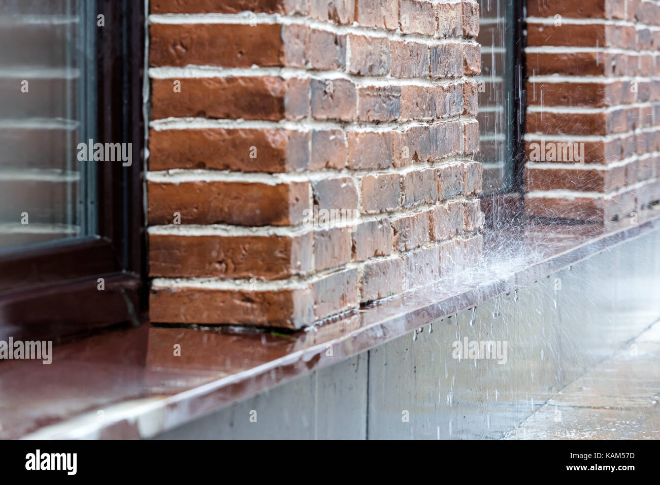 heavy rain pouring on pavement on red brick wall background Stock Photo ...