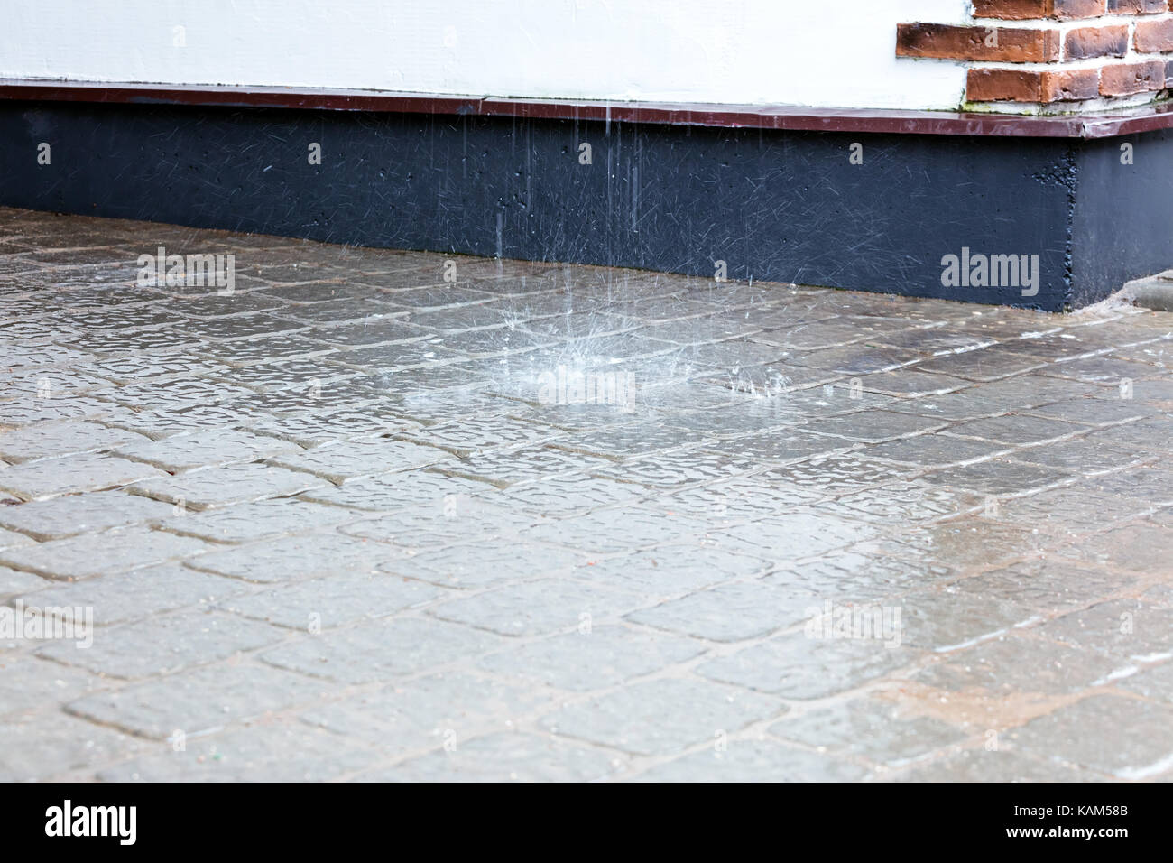 flooded street pavement. water splashes on sidewalk during heavy rain ...