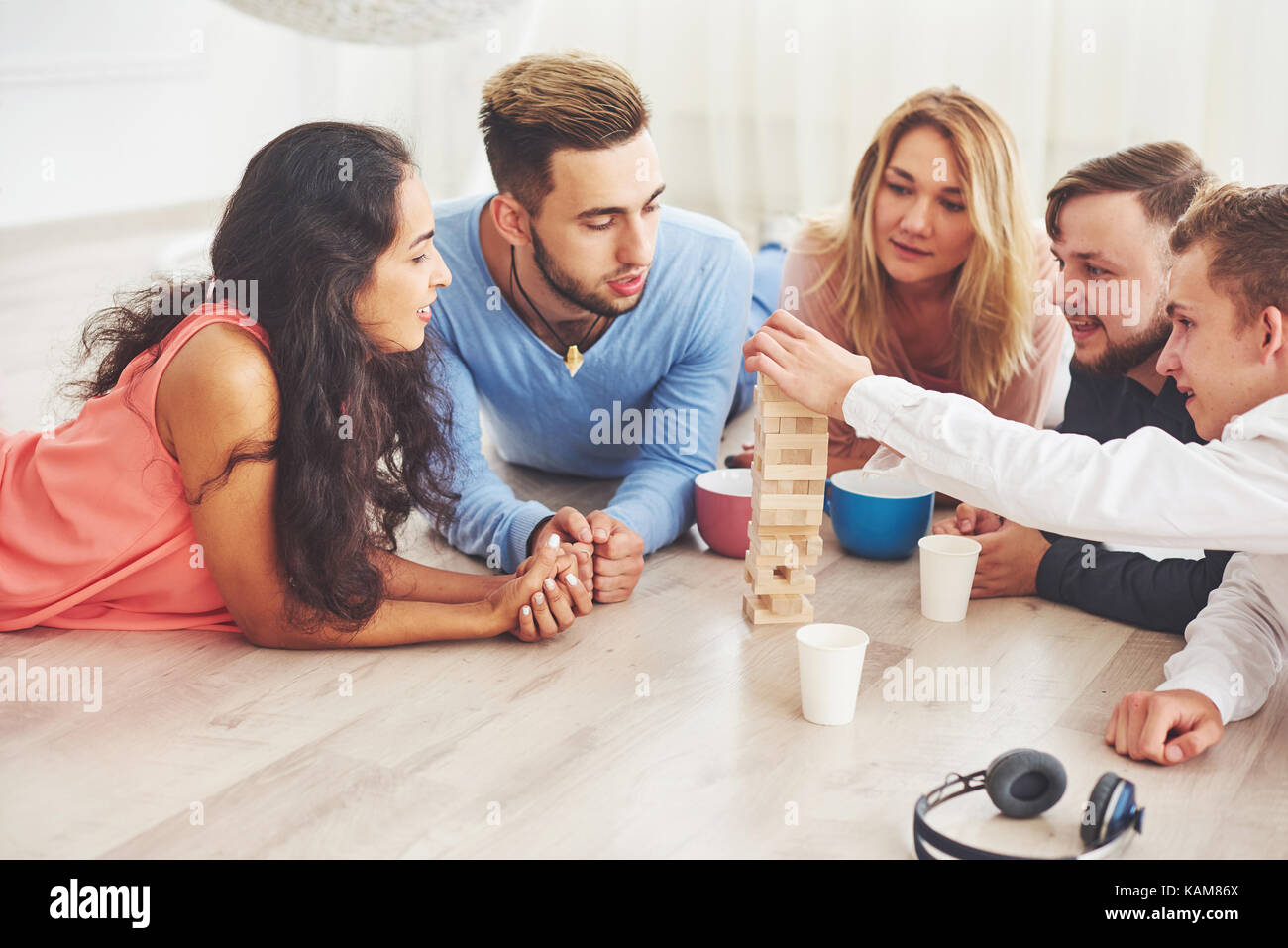 Group of creative friends sitting at wooden table. People having fun ...