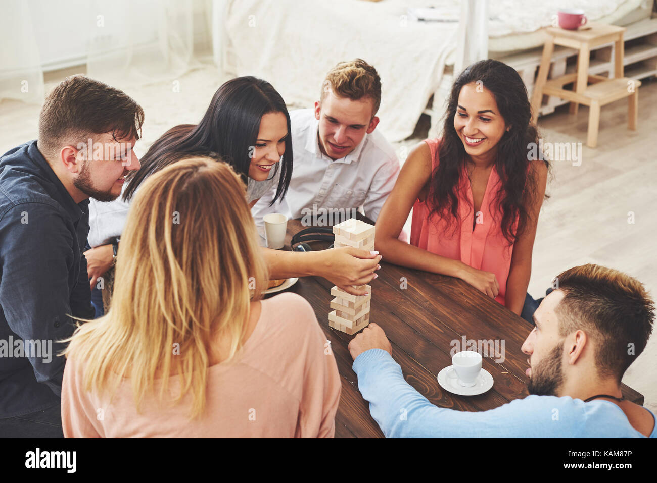 Group of creative friends sitting at wooden table. People having fun ...