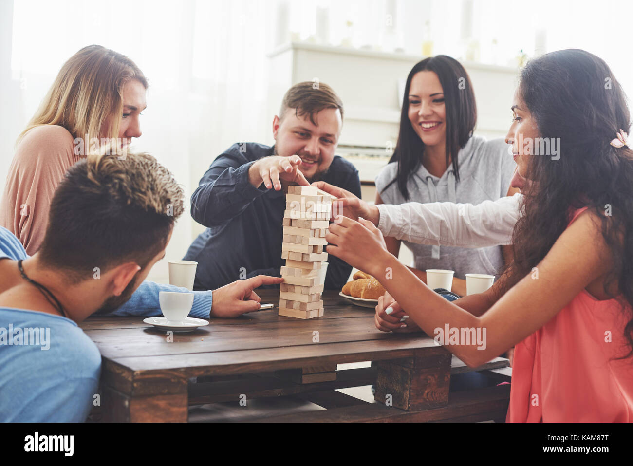 Group of creative friends sitting at wooden table. People having fun ...