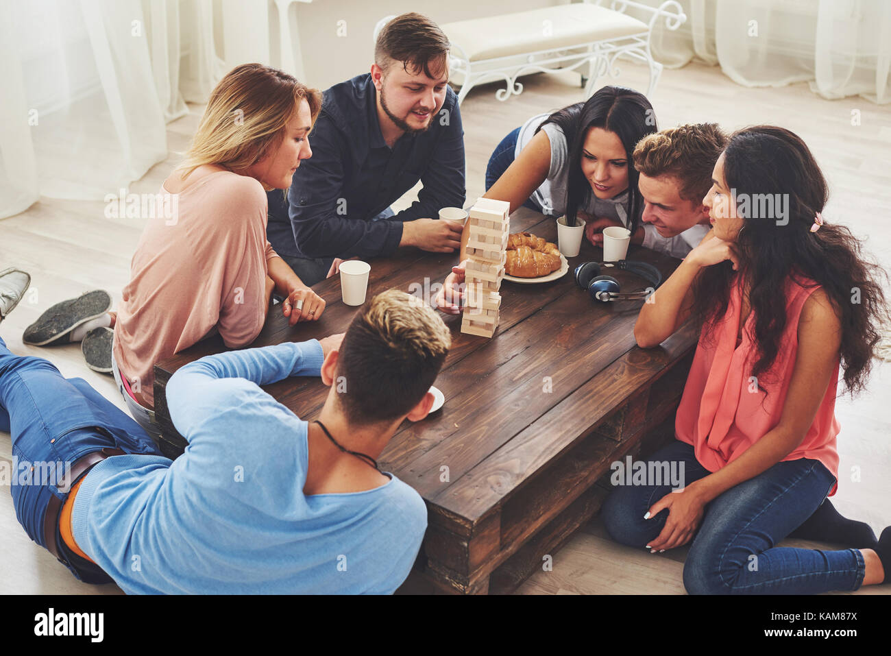 Group of creative friends sitting at wooden table. People having fun ...