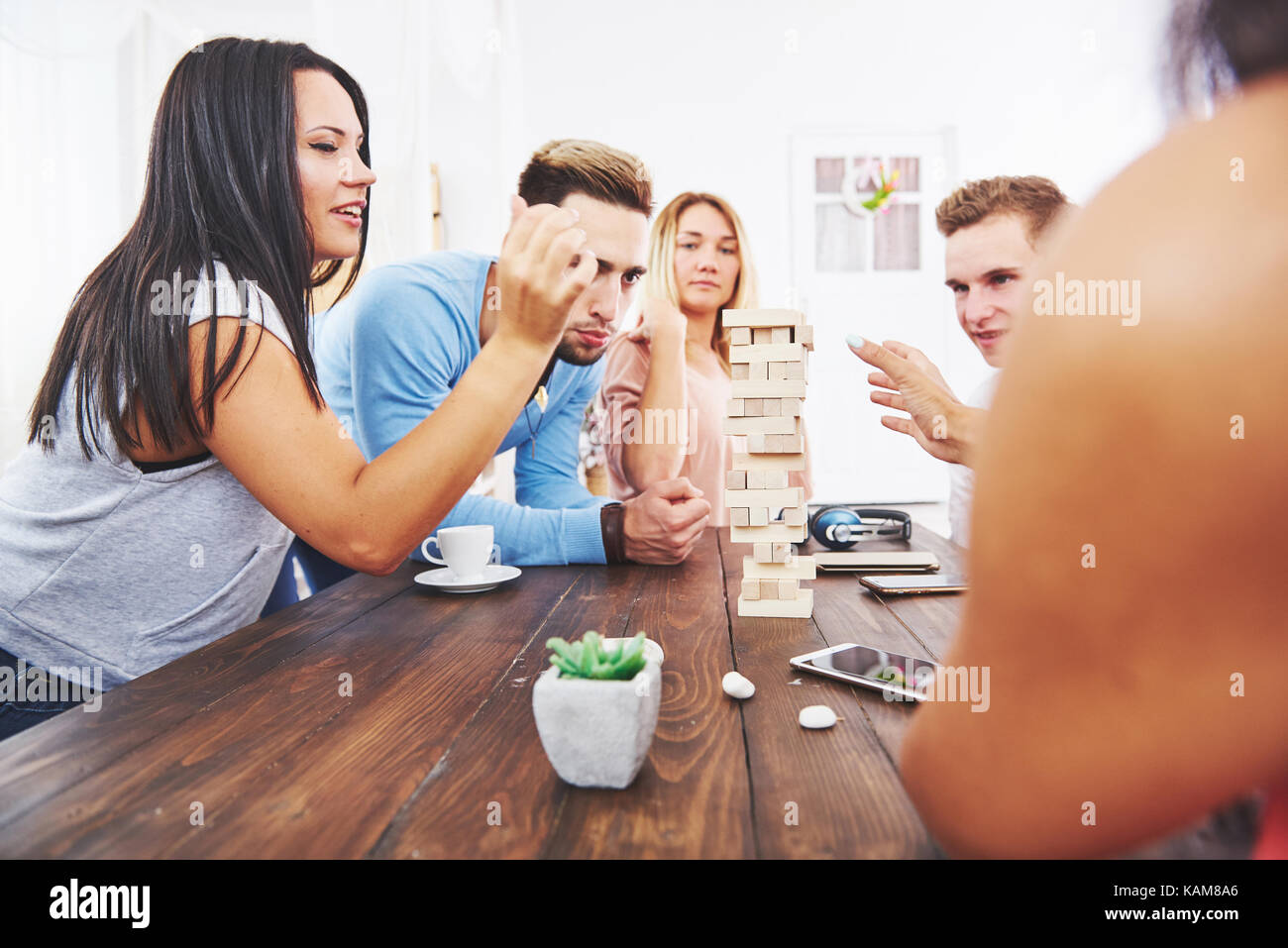 Group of creative friends sitting at wooden table. People having fun ...
