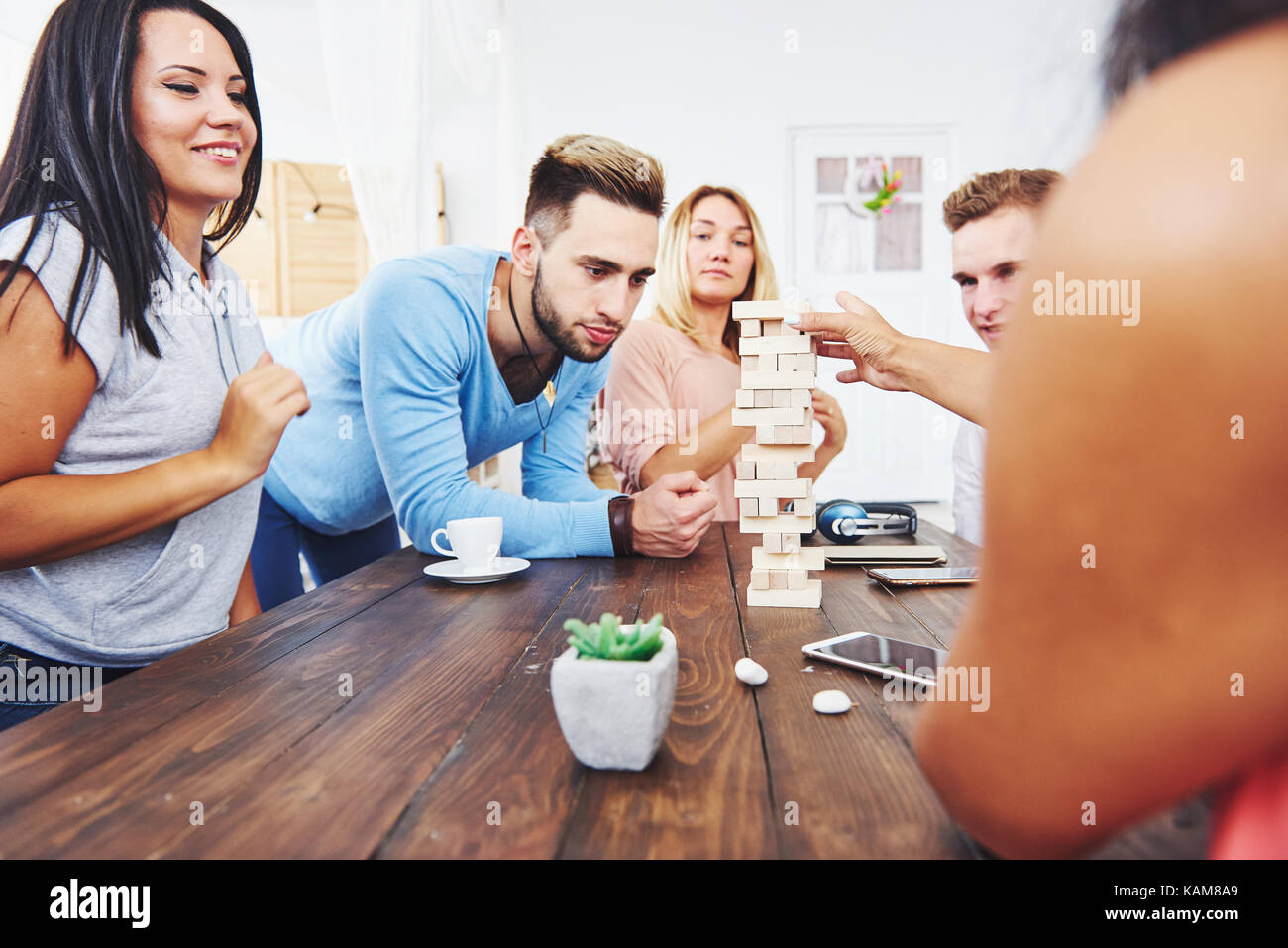 Group of creative friends sitting at wooden table. People having fun ...